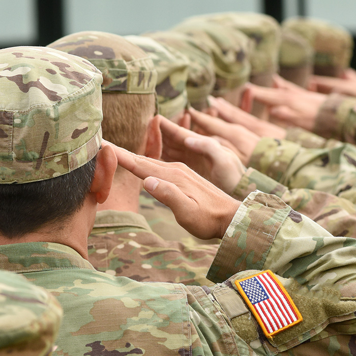 Soldiers standing at attention saluting.