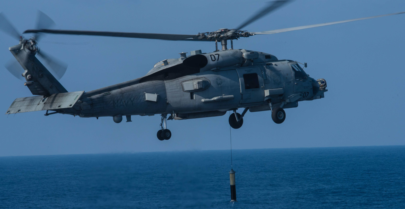 Navy helicopter over ocean.
