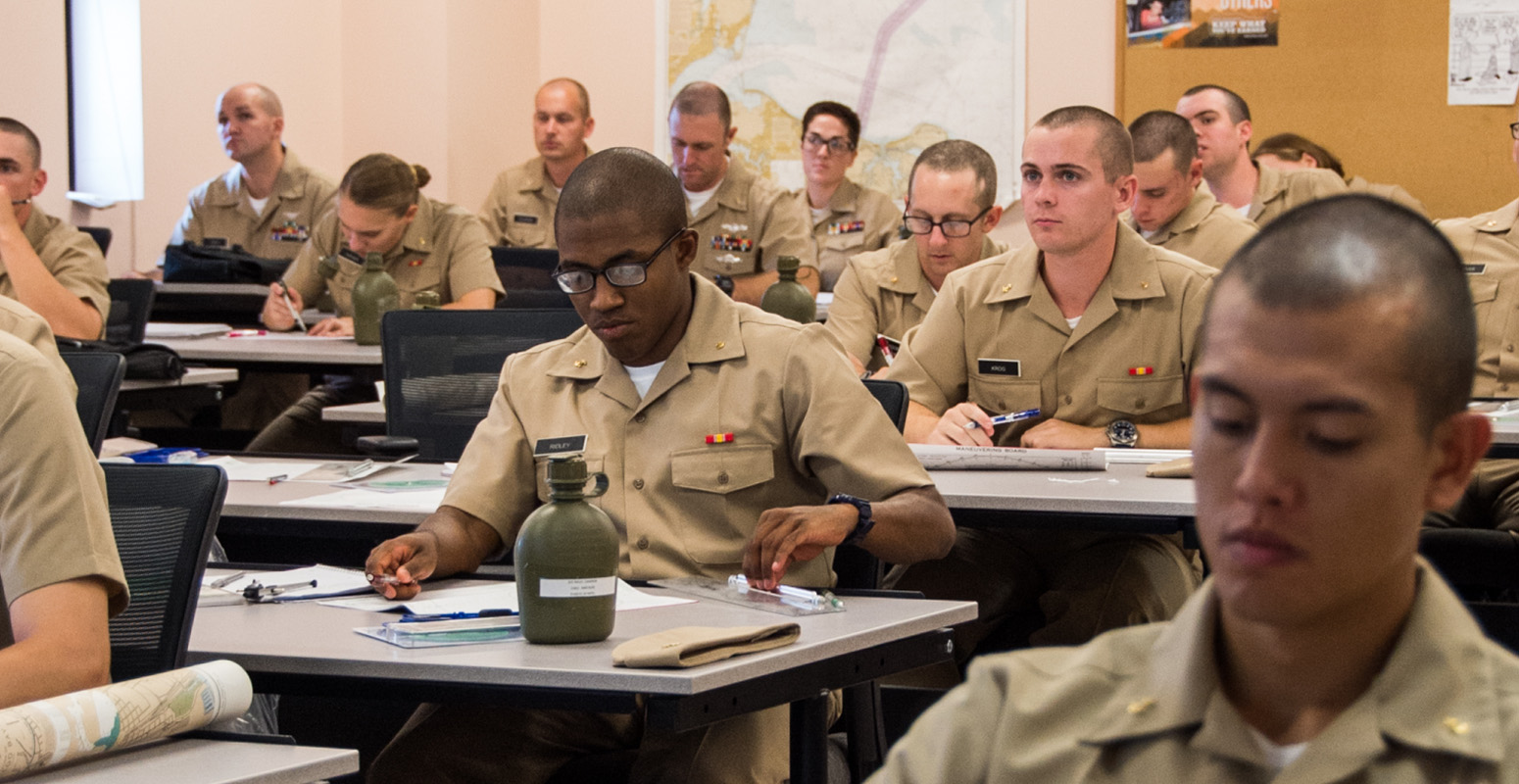 NETC students in uniform sitting in a classroom learning by on-site ...