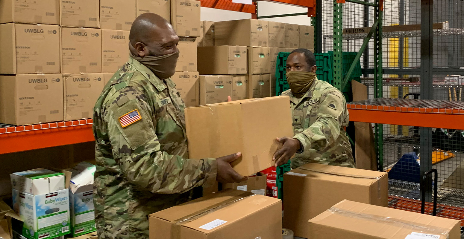 Soldiers carrying and loading boxes on shelves.