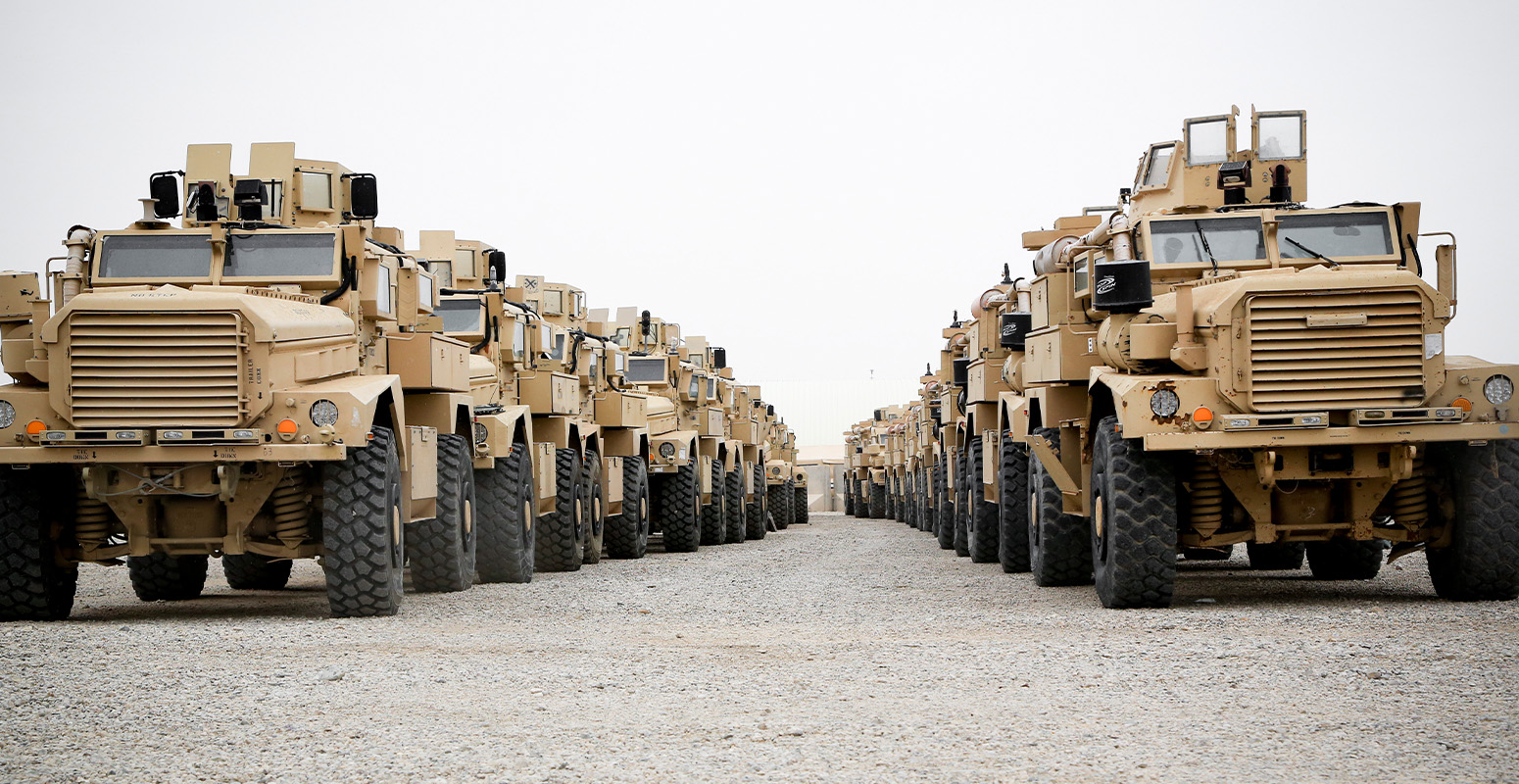 Mine Resistant Ambush Protected (MRAP) vehicles in two rows outside.